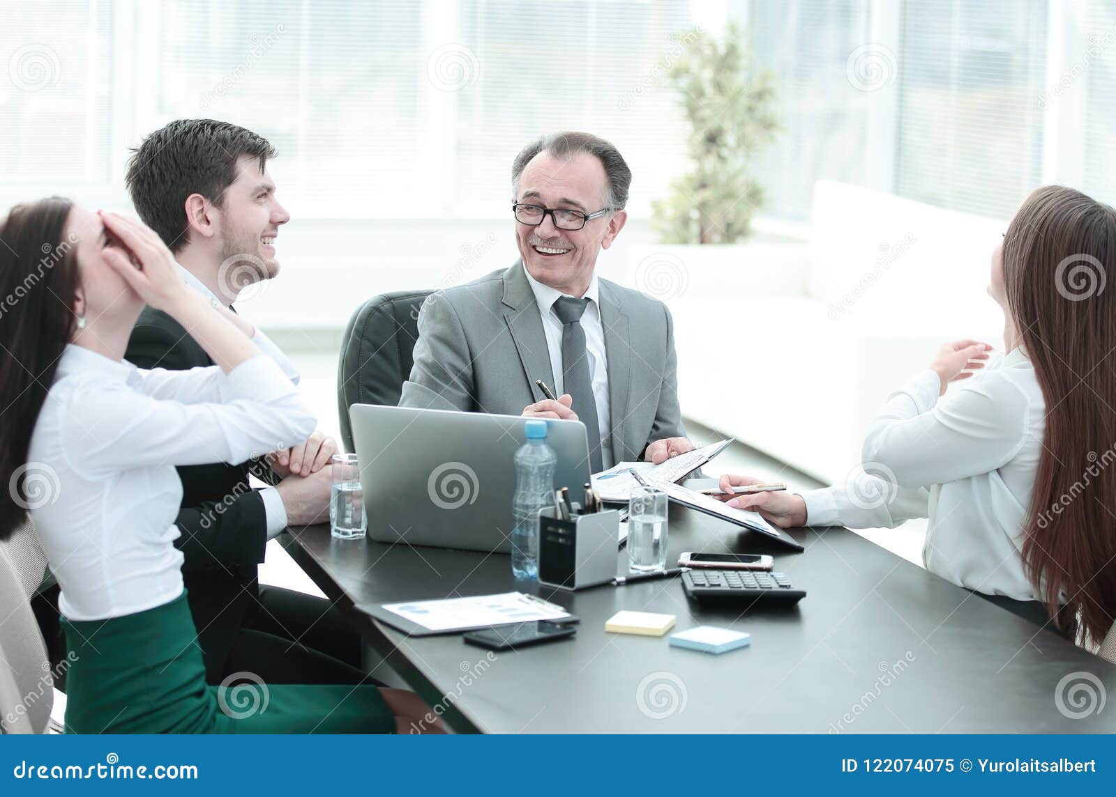Manager Discussing Work Issues with His Assistants Behind a Desk Stock ...