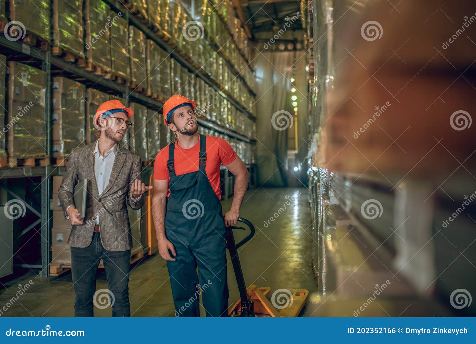 Manager Inspecting Warehouse while Warehouse Worker Showing Him the ...