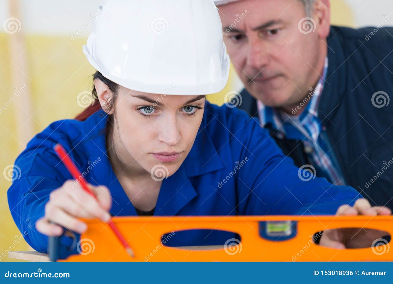 Manager Overseeing Young Lady Using Spirit Level Stock Photo - Image of ...