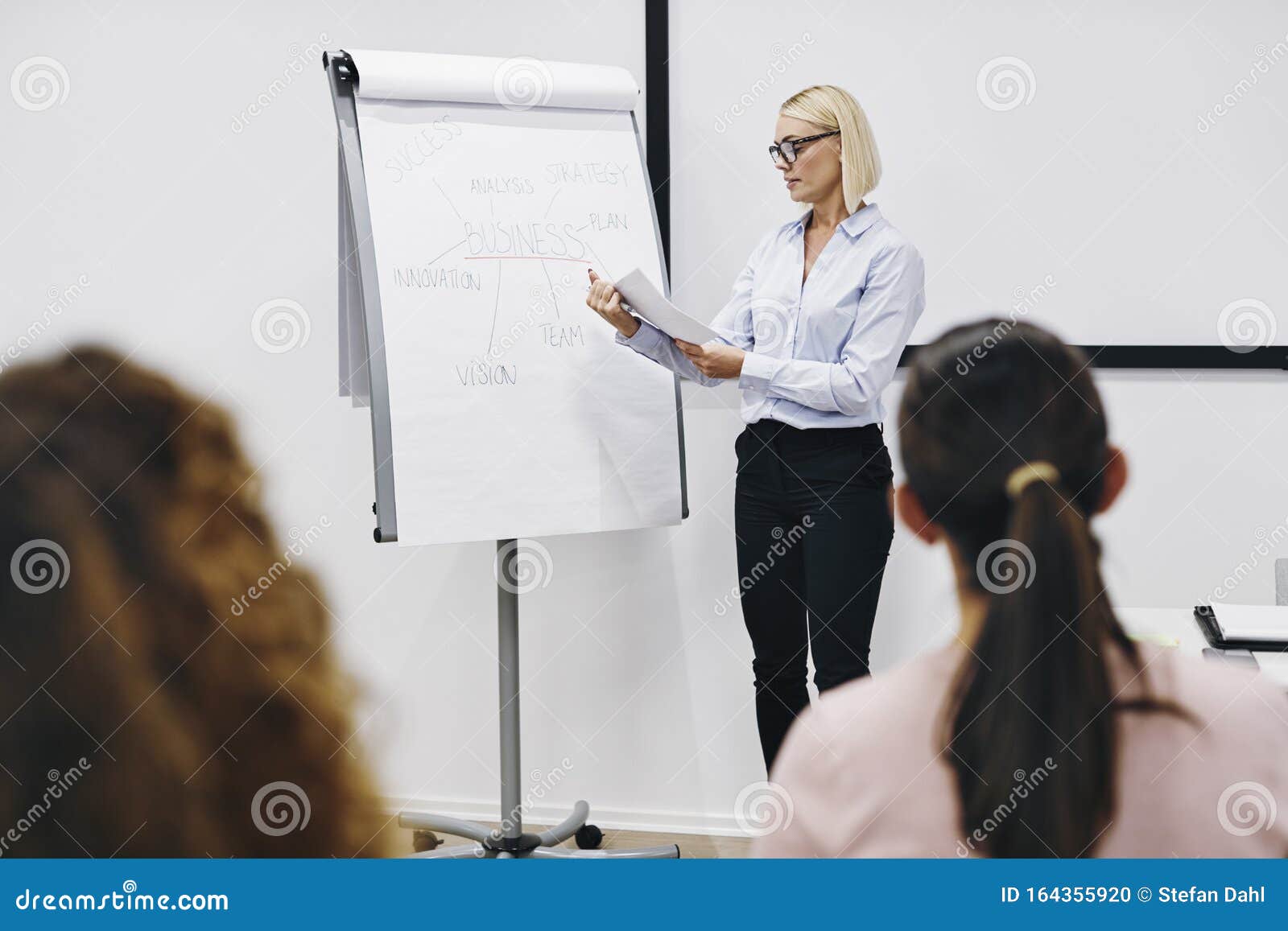 Manager Reading Paperwork during an Office Presentation Stock Photo ...