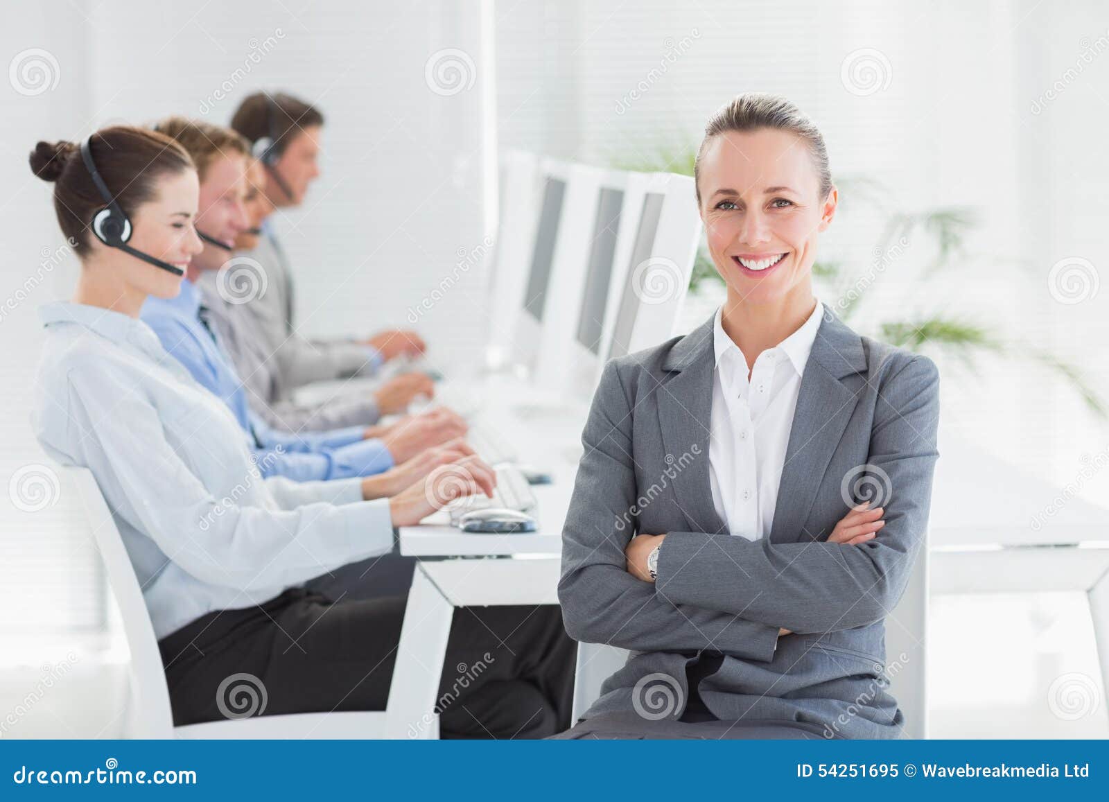 Manager Smiling at Camera with Her Staff Behind Stock Image - Image of ...