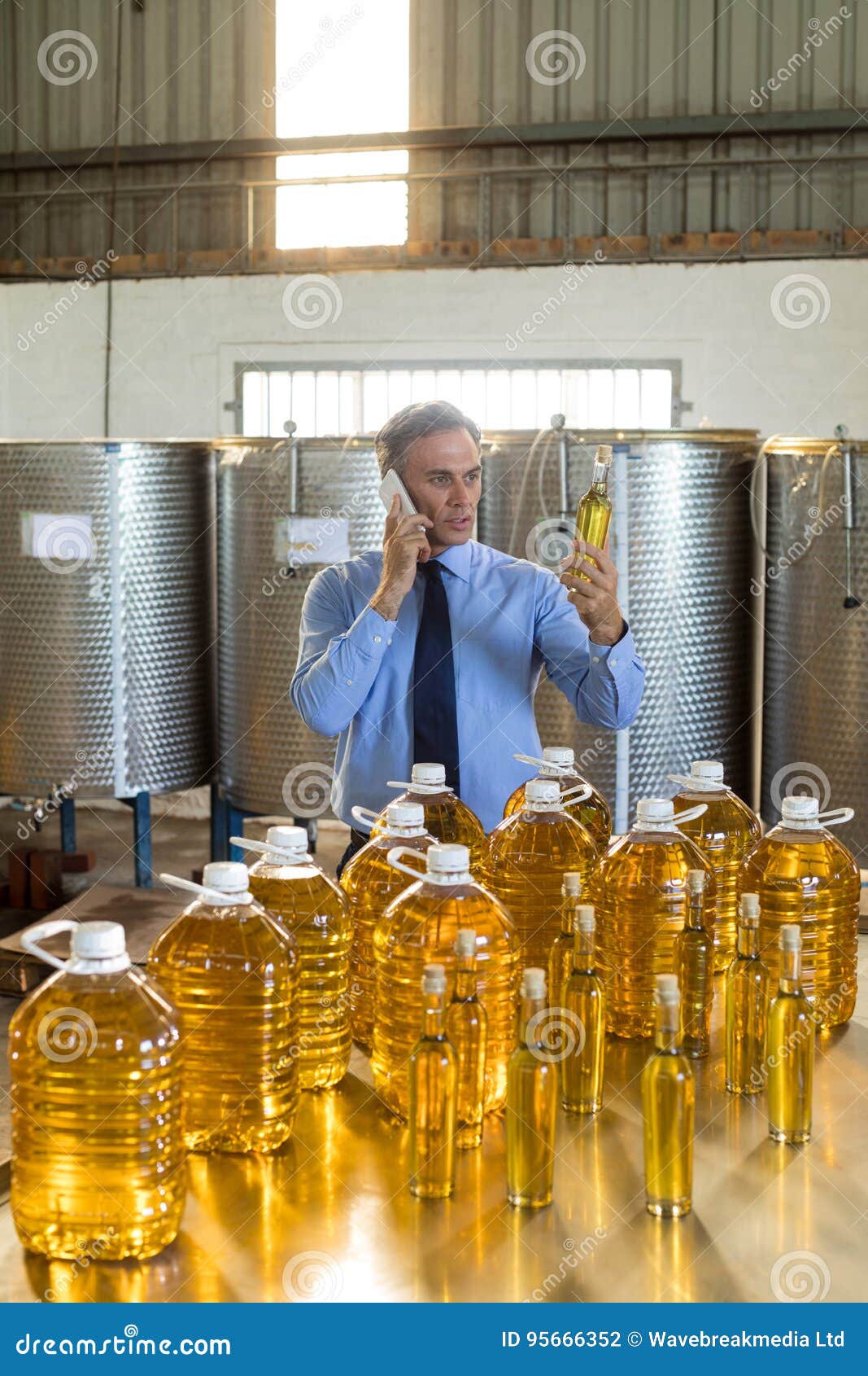 Manager Talking on Mobile Phone while Examining Olive Oil Stock Photo ...