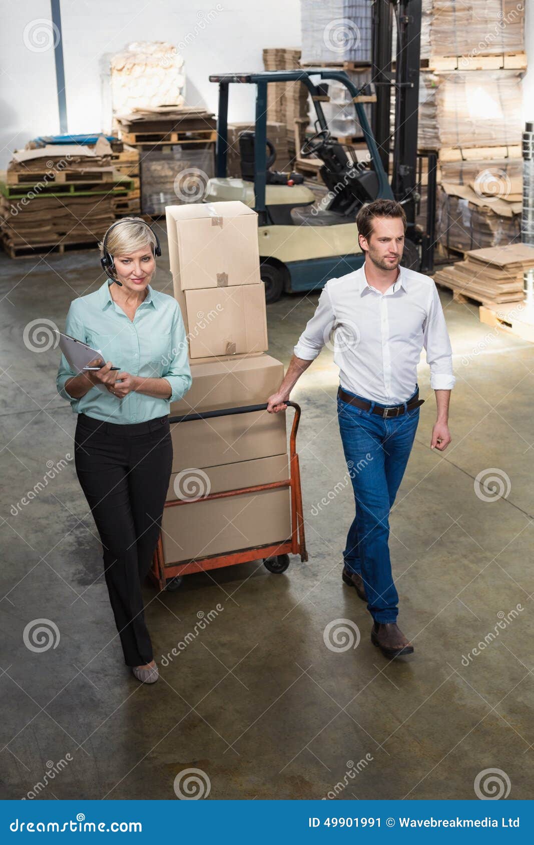 Manager Walking with Her Colleague Pulling Trolleys Stock Image - Image ...