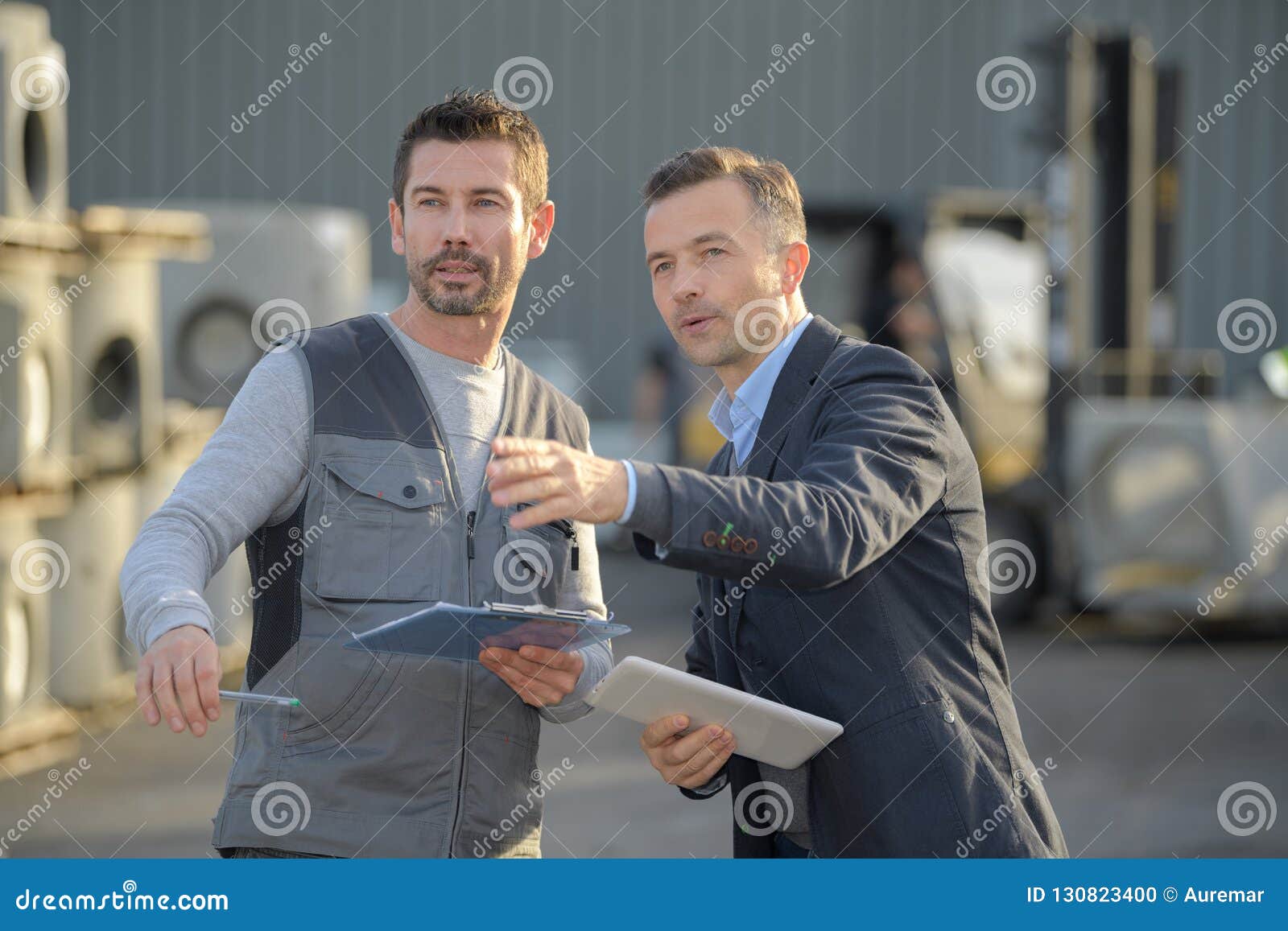 Manager with Worker Discussing Over Clipboard in Industry Stock Photo ...