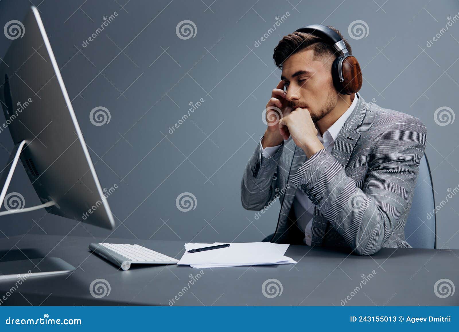Manager Working at the Computer in Headphones in the Office ...