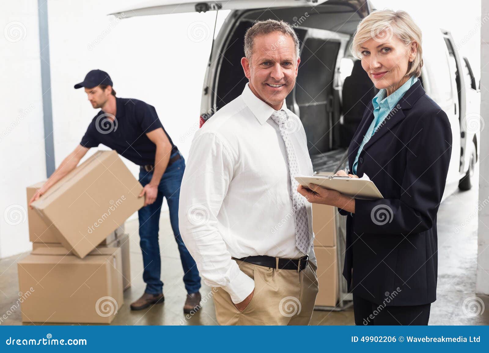 Managers Smiling at Camera with Delivery Driver Behind Stock Photo ...