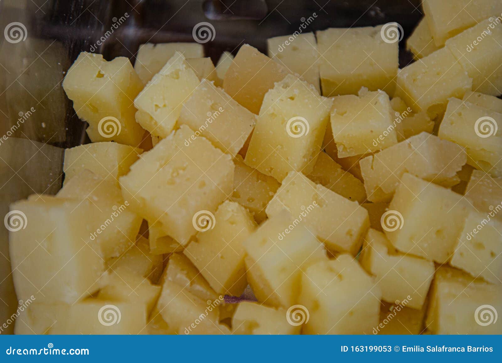 Manchego Cheese Split into Square Pieces for Tasting in the Foreground ...