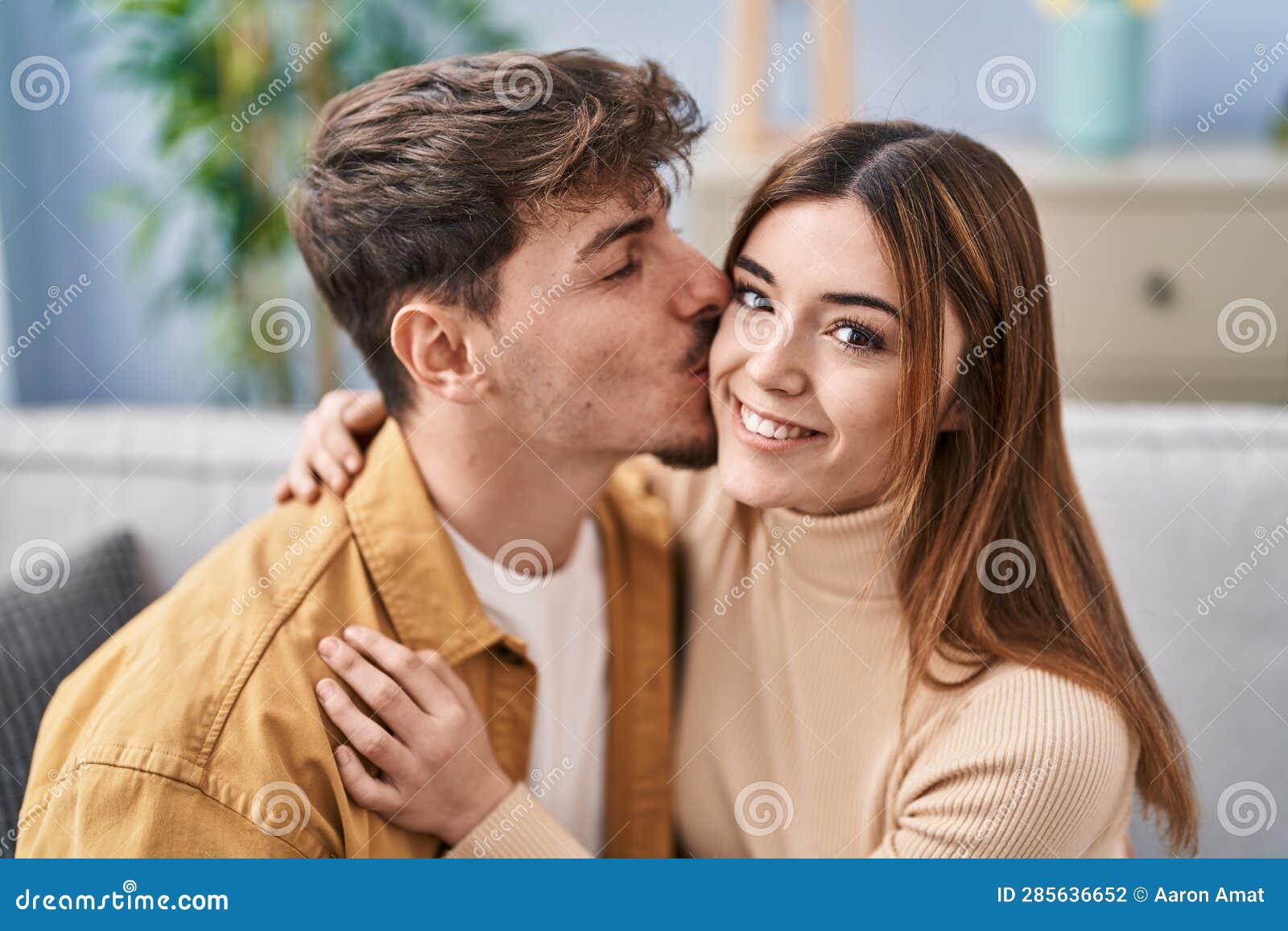 Mand And Woman Couple Kissing And Hugging Each Other Sitting On Sofa At