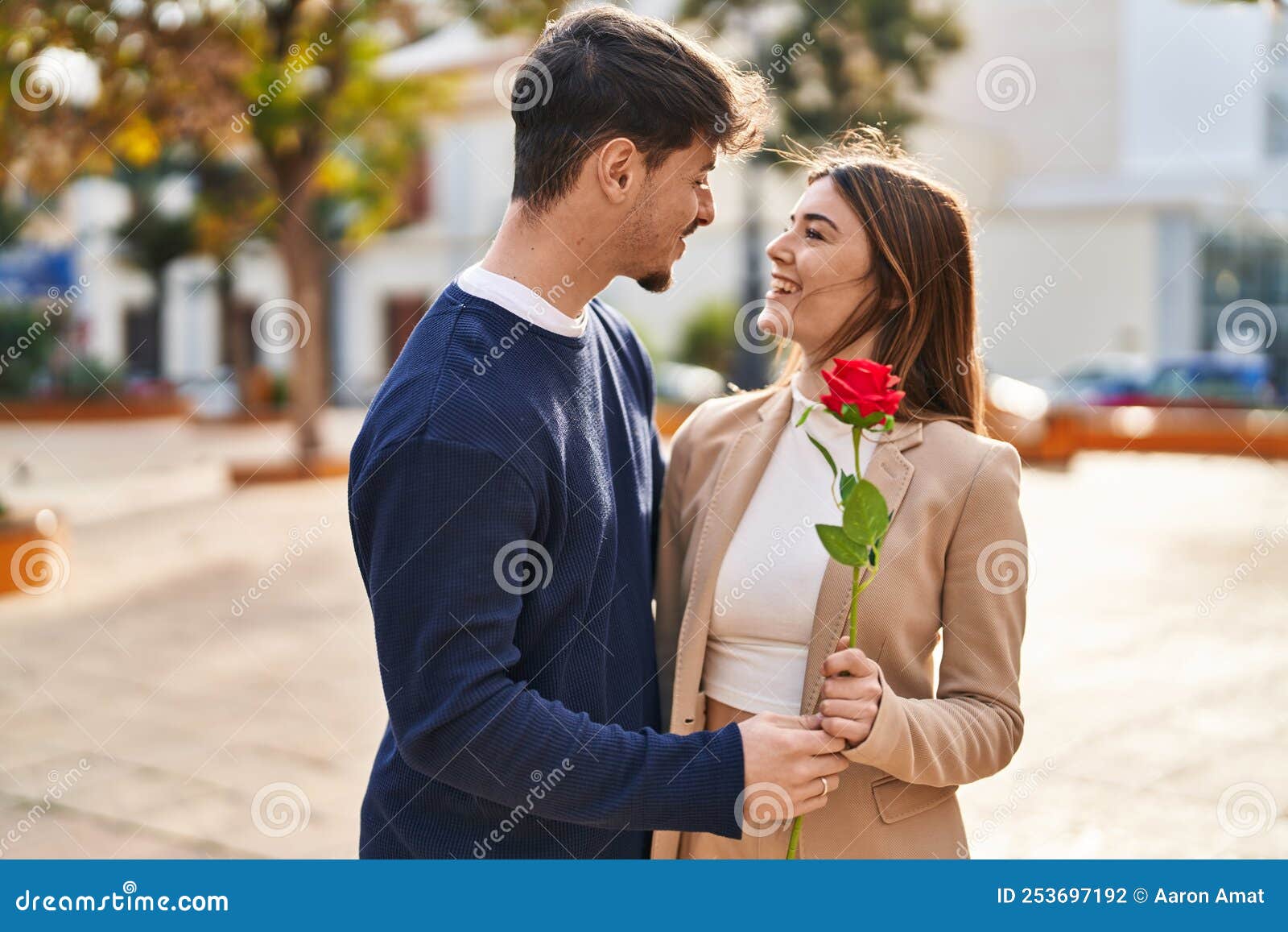 Mand And Woman Couple Suprise With Rose Standing Together At Park Stock