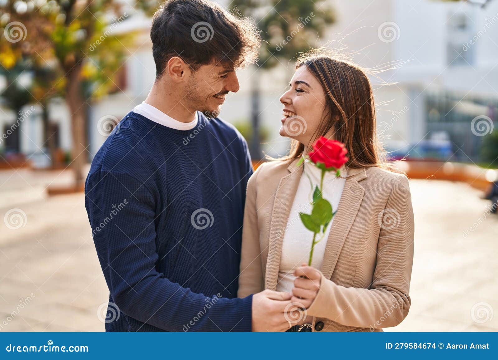 Mand And Woman Couple Suprise With Rose Standing Together At Park Stock
