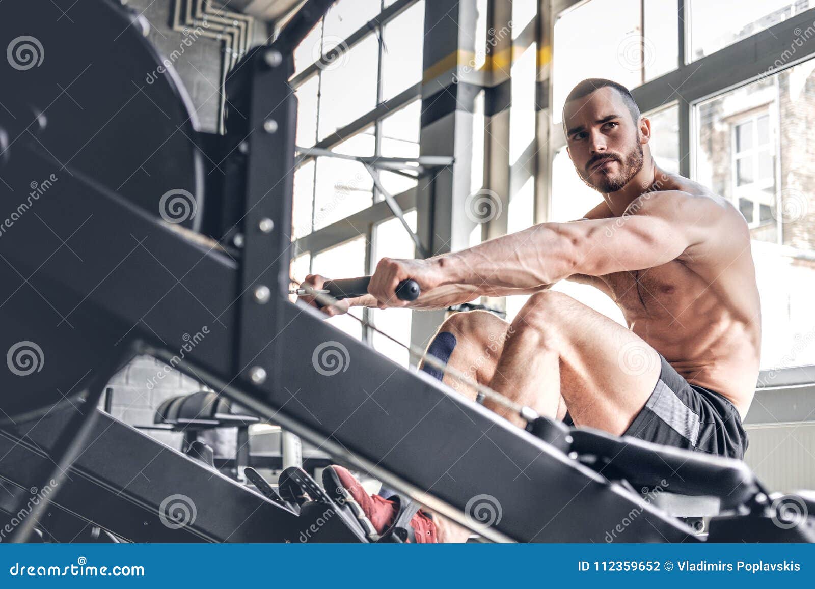 A Mandoing Workouts on a Back with Power Exercise Machine. Stock Photo ...