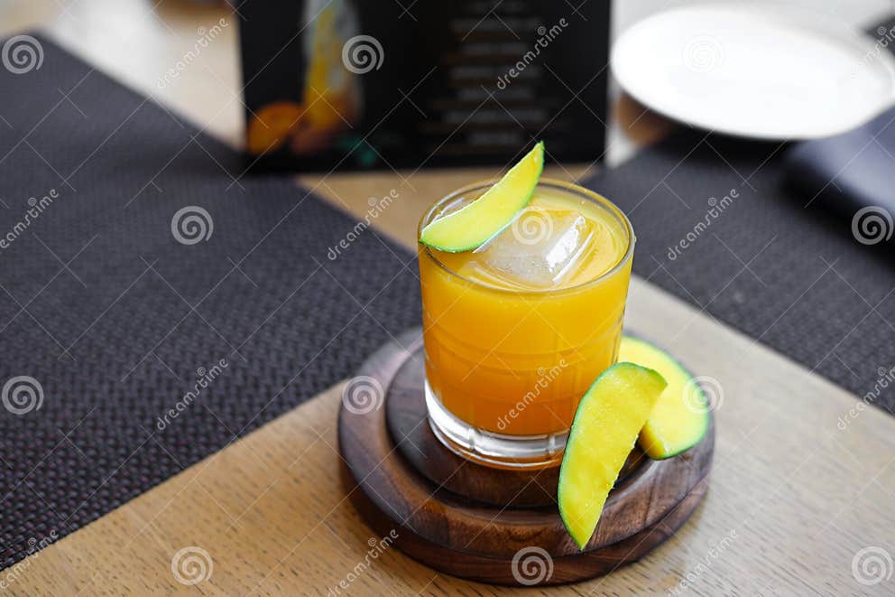 Mango Juice on Restaurant Table with Raw Mango Slice on Side Stock ...