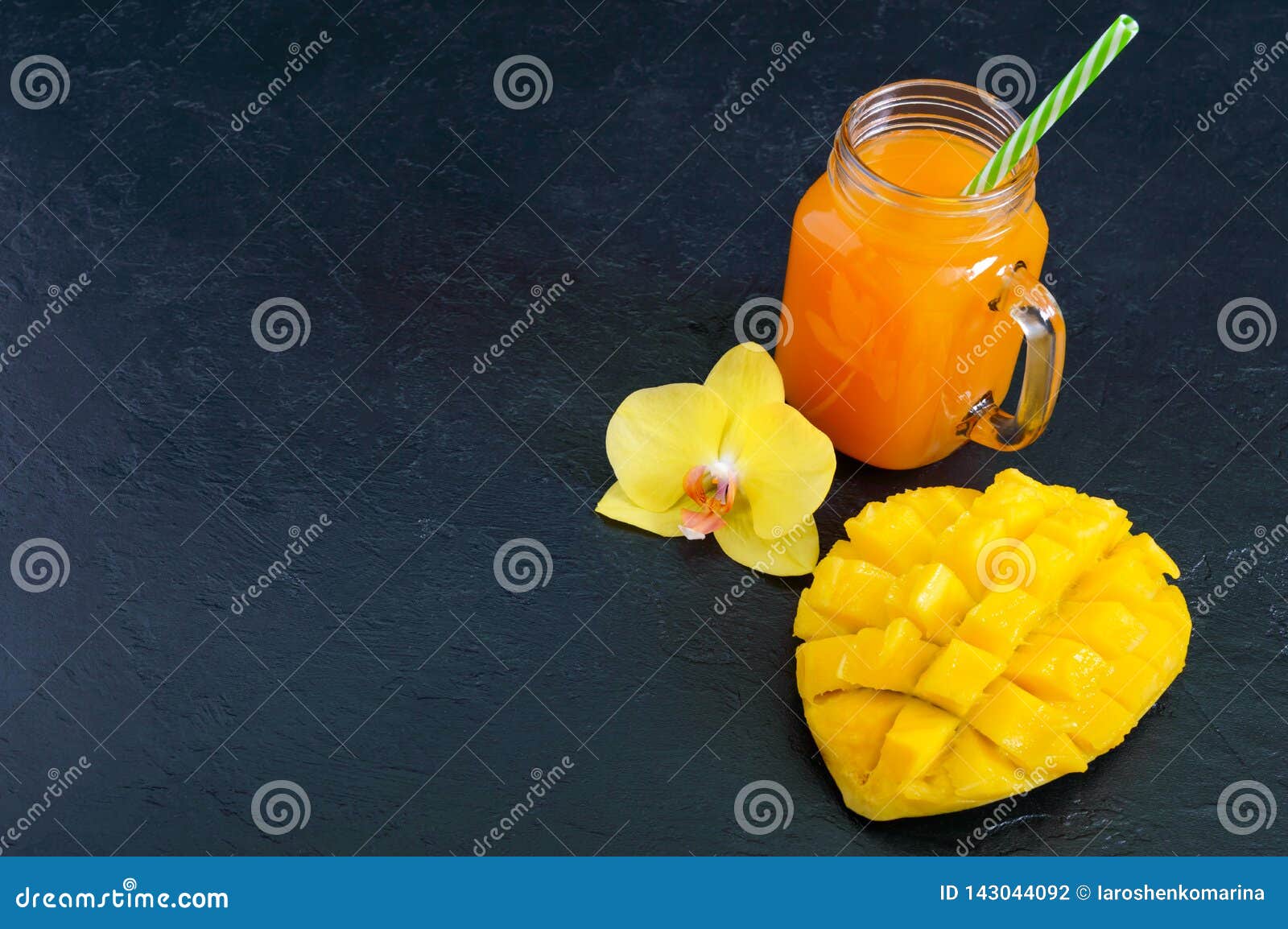 Mango Smoothie in a Glass Jar and Fresh Mango on a Black Background ...