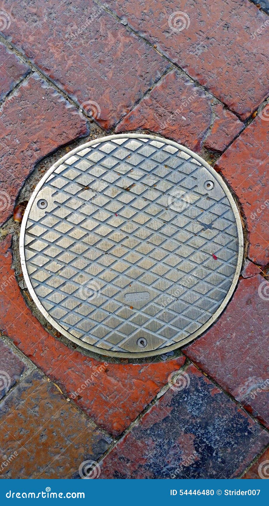 Manhole Cover on a Brick Road Stock Photo - Image of cast, cobblestone ...