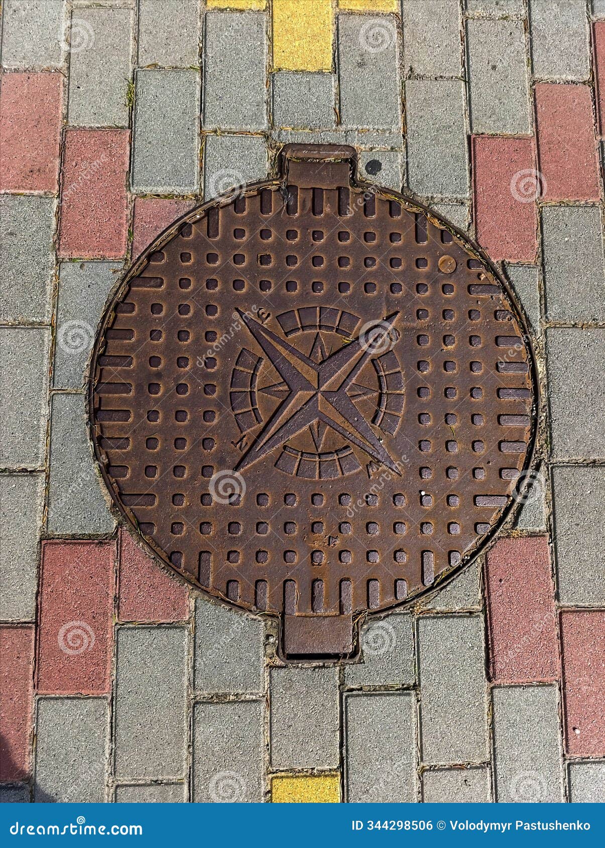 A Manhole Cover with a Compass Design on it on a Sidewalk Stock Photo ...