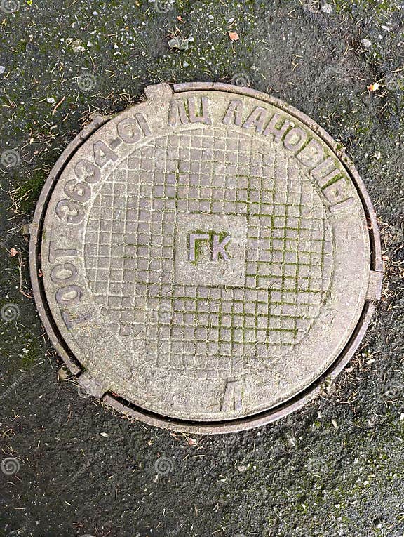 A Manhole Cover on the Ground with a Grid Pattern on it Stock Photo ...
