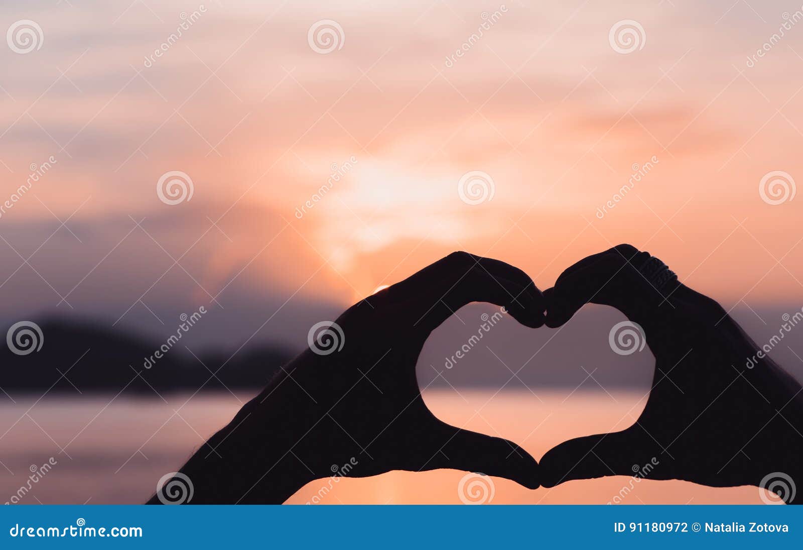 Mani Che Formano Una Forma Del Cuore Con Il Tramonto Fotografia Stock ...