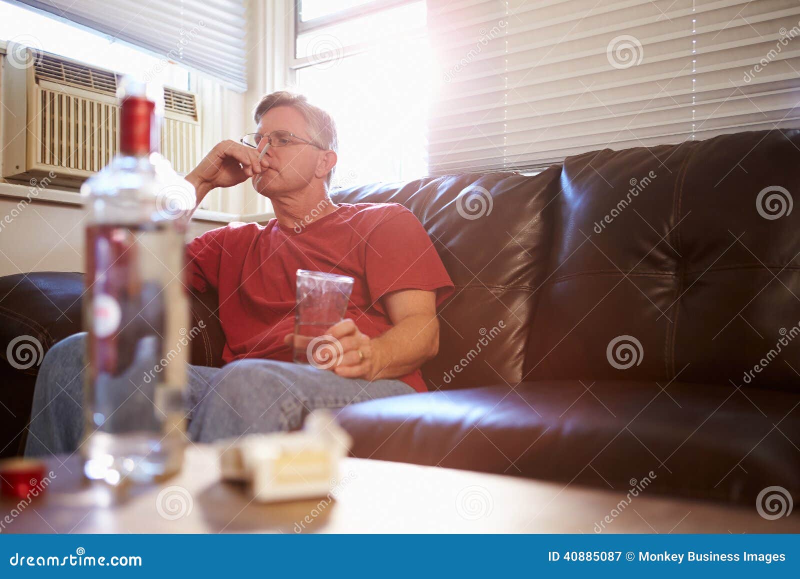 Mann, Der Auf Sofa with Bottle of Vodka Und Zigaretten Sitzt Stockbild ...