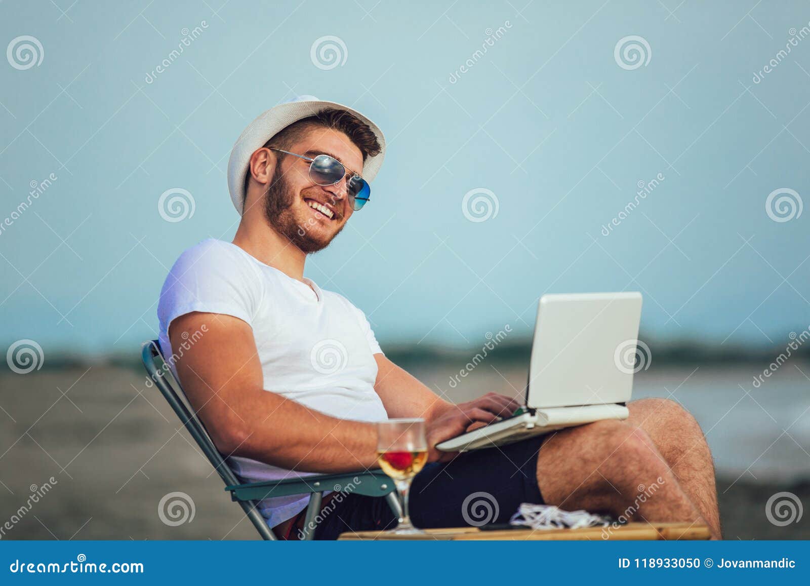 Mann, Der Mit Computer Auf Dem Strand Arbeitet Stockfoto - Bild von ...