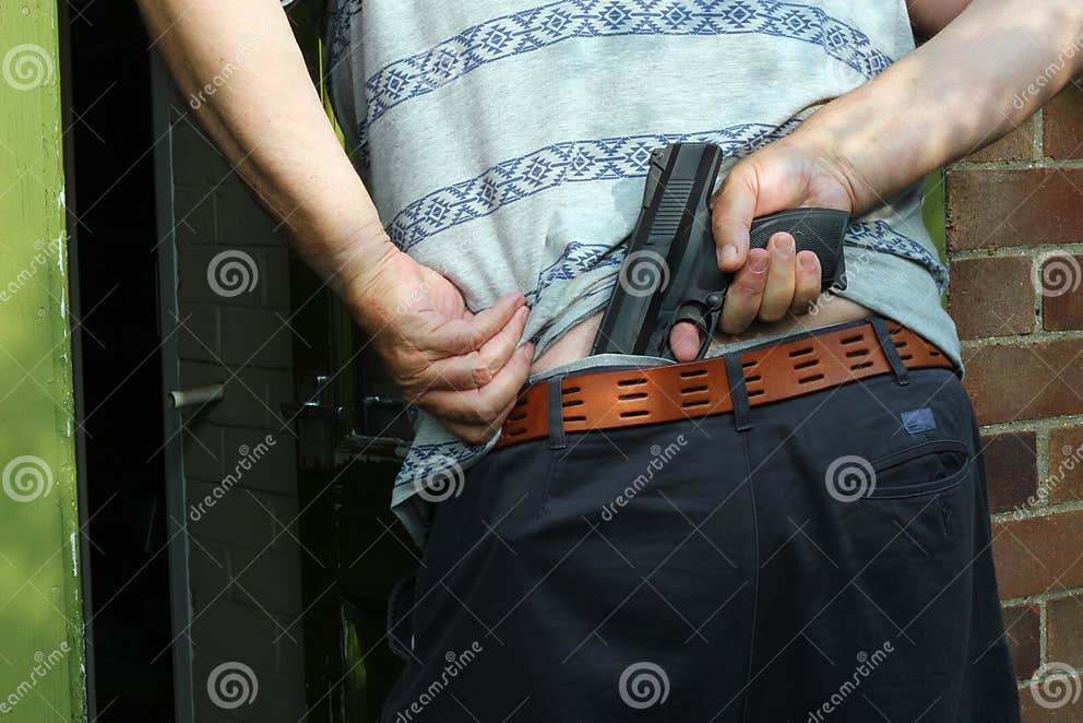 Mann Mit Einer Verborgenen Waffe. Stockfoto - Bild von hose, riemen ...