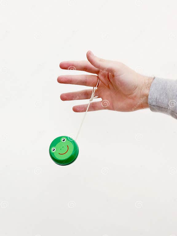Mano con un yo-yo verde immagine stock. Immagine di isolato - 39250411