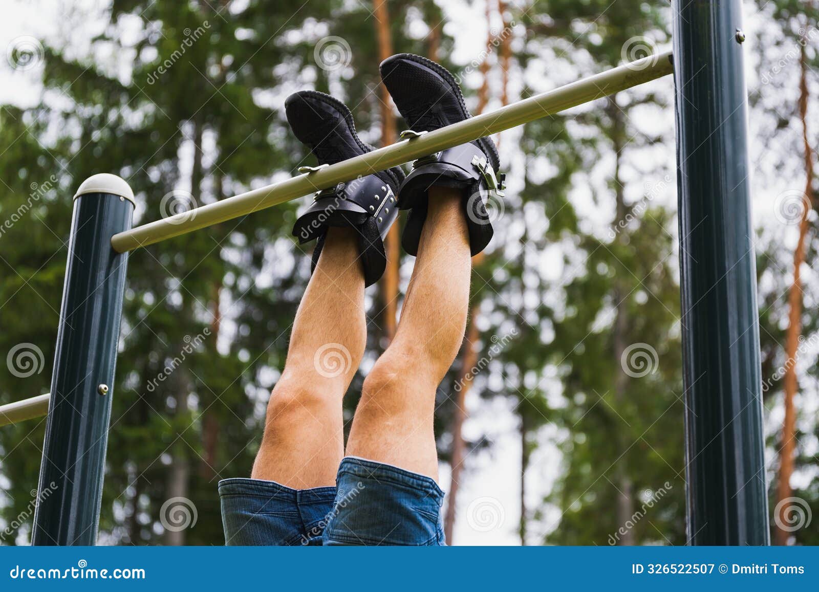 A Mans Legs in Gravity Boots Hangs on a Horizontal Bar Outdoors on a ...