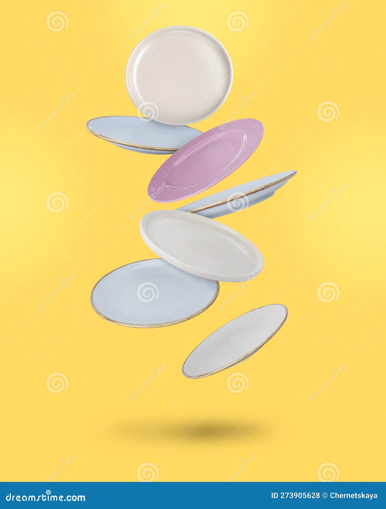 Many Different Plates Falling on Yellow Background Stock Photo - Image ...