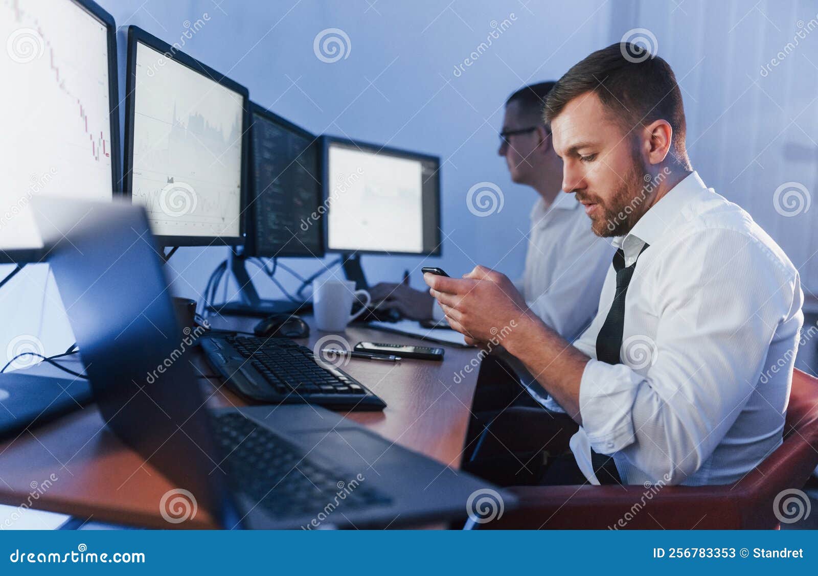 Many Displays on the Table. Two Stock Traders Working in the Office ...
