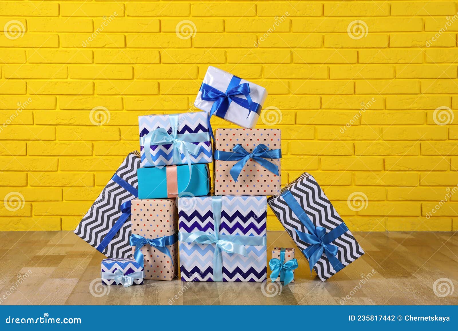 Many Gift Boxes Near Yellow Brick Wall Stock Photo - Image of ...