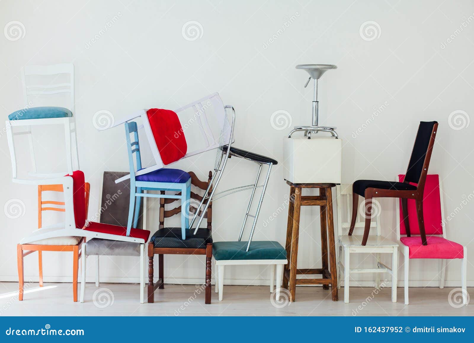 Many Multicolored Chairs in the Mess of the White Room Stock Photo ...