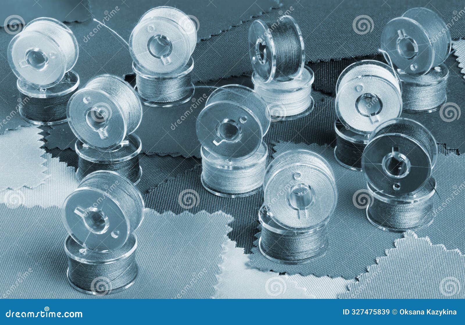 Many Plastic Bobbins for Sewing Machine on Different Fabrics Stock ...