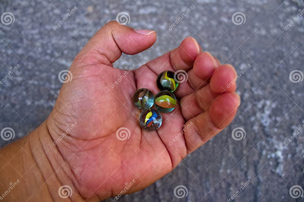 Marbles on a hand stock image. Image of hand, marbles - 212588539