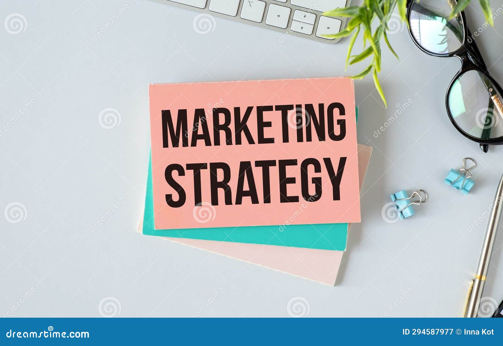 MARKETING STRATEGY Text on a Notebook with Pen and Pencil on White ...