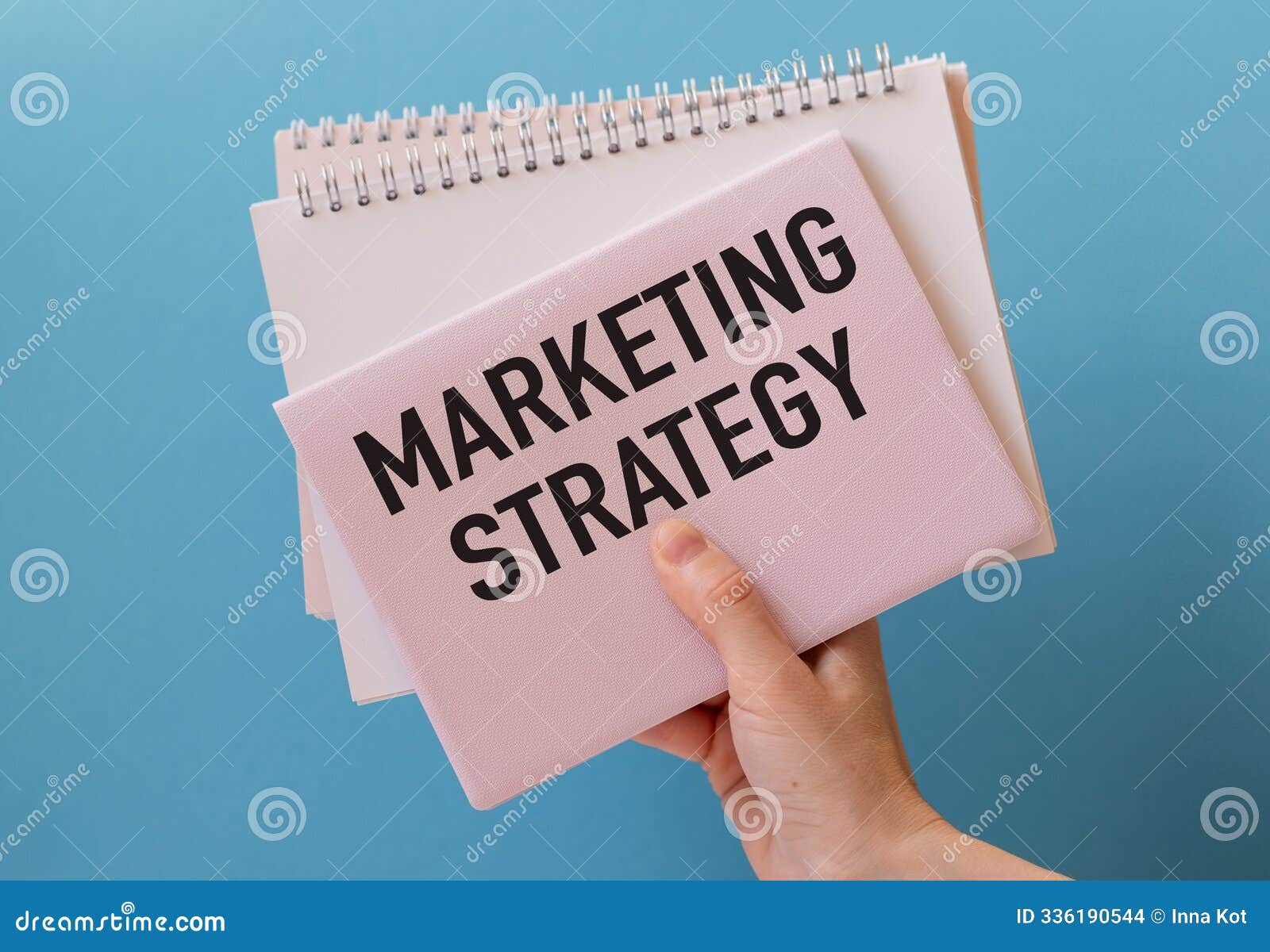 Marketing Strategy Text on a Paper in Hand with Keyboard on Blue ...