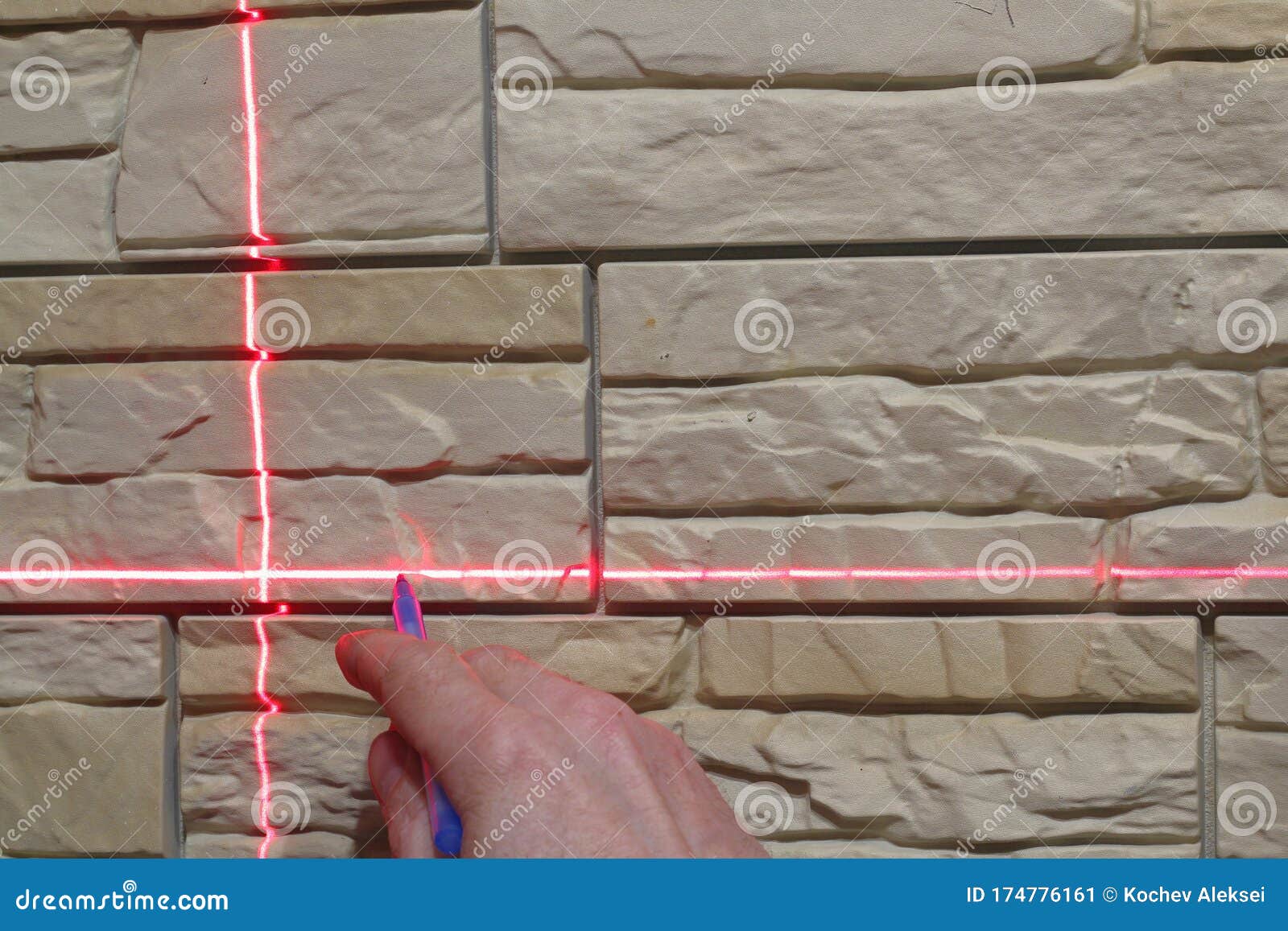 Marking a Wall Using a Laser Level. Red Beam on a Stone Wall. Repair ...