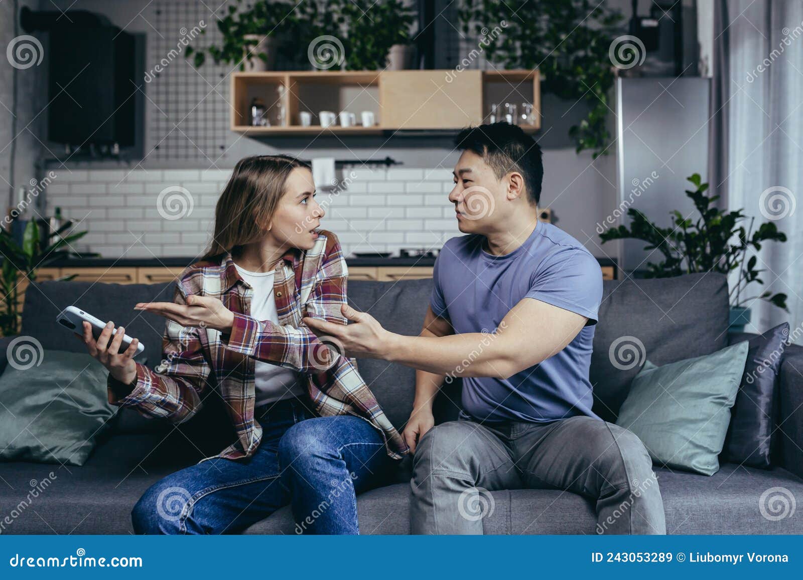 Married Couple Man And Woman Sitting On The Couch At Home And Arguing