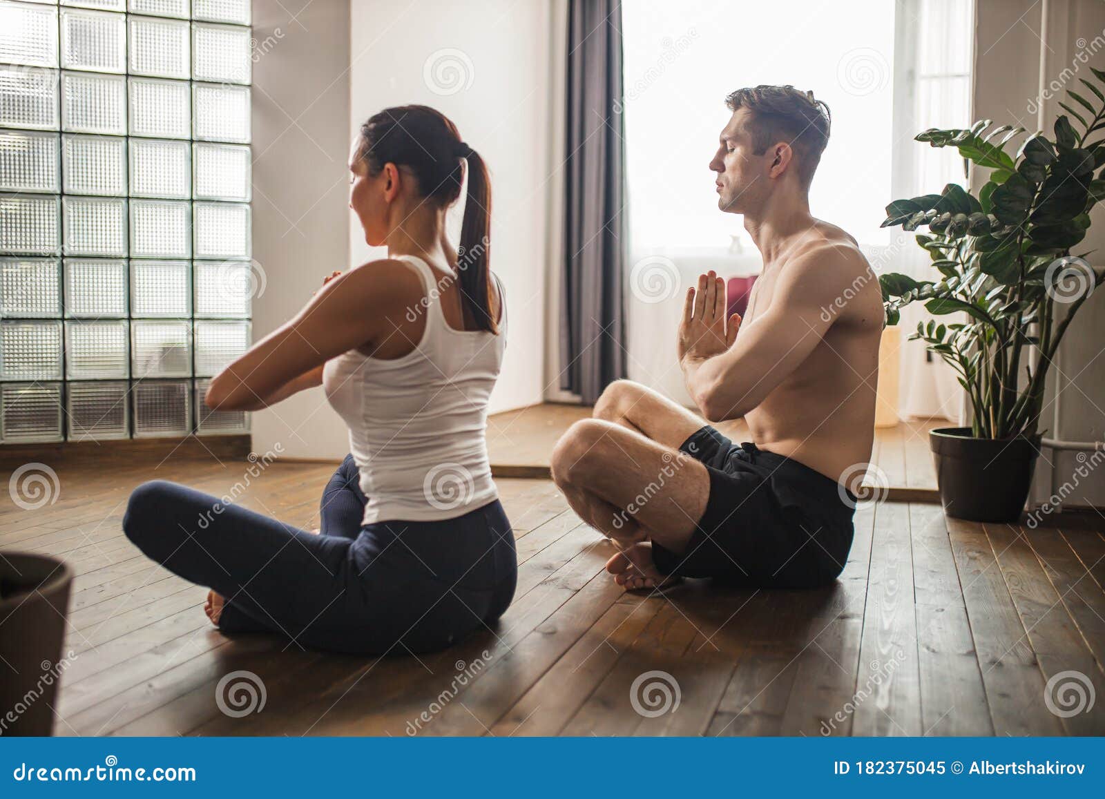 Married Couple Meditating Do Yoga Exercises At Home Stock Image