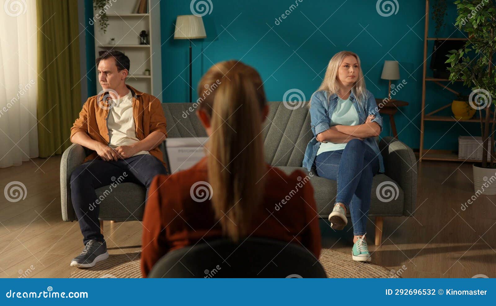 Married Couple Sitting On Different Sides Of The Couch In Front Of The