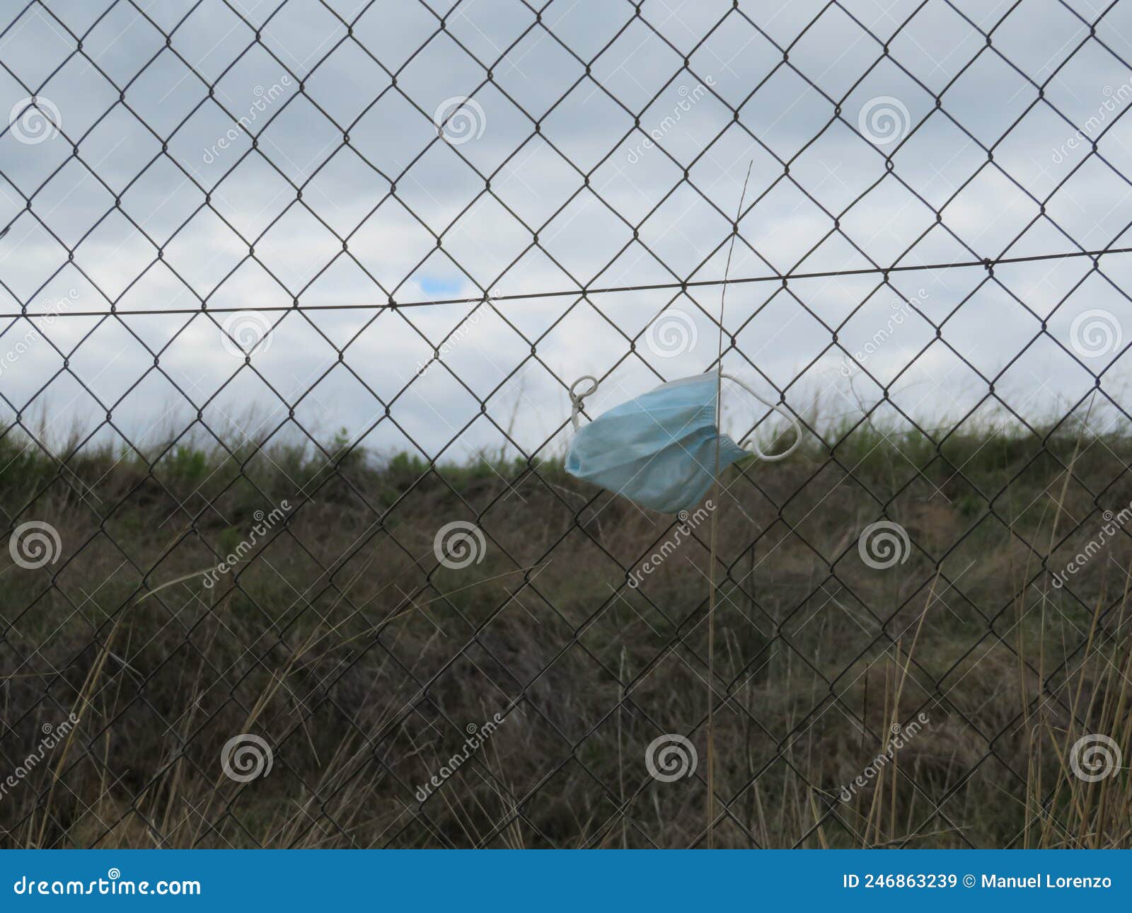 Mask Abandoned in the Garbage Dragged by the Air Trapped in a Fence ...