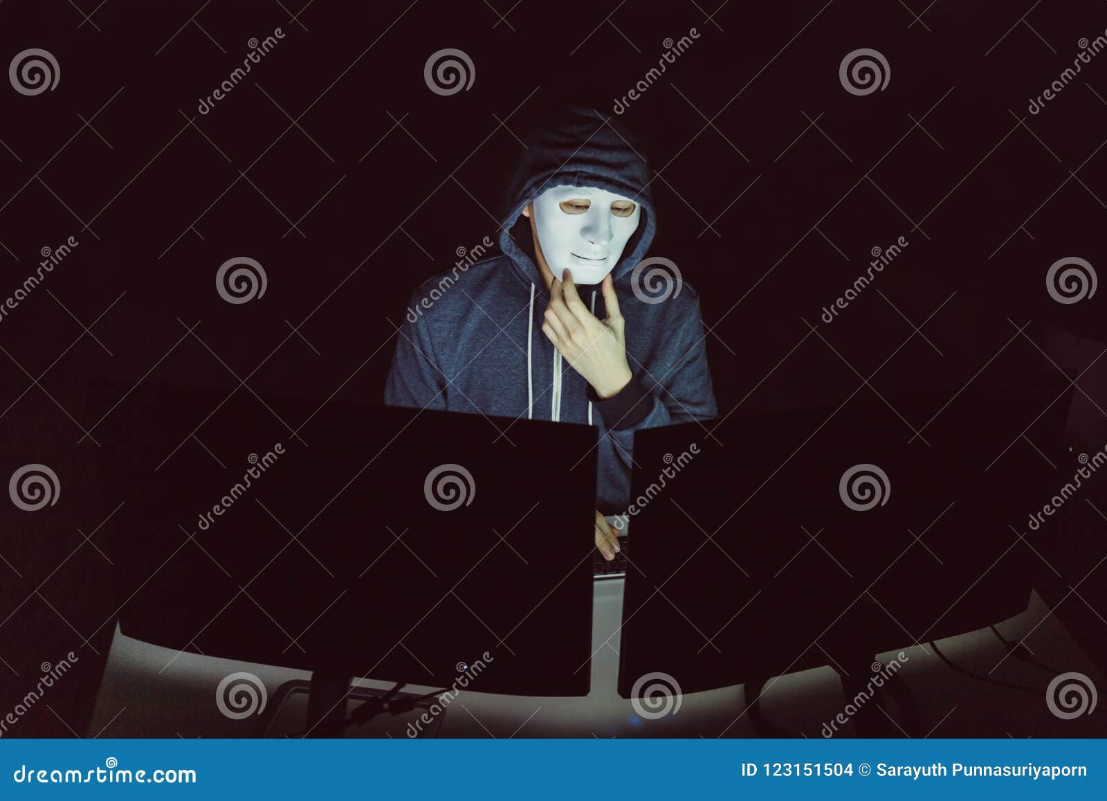 Masked Hacker Under Hood Using Computer To Hack Into System And Trying To Commit Computer Crime