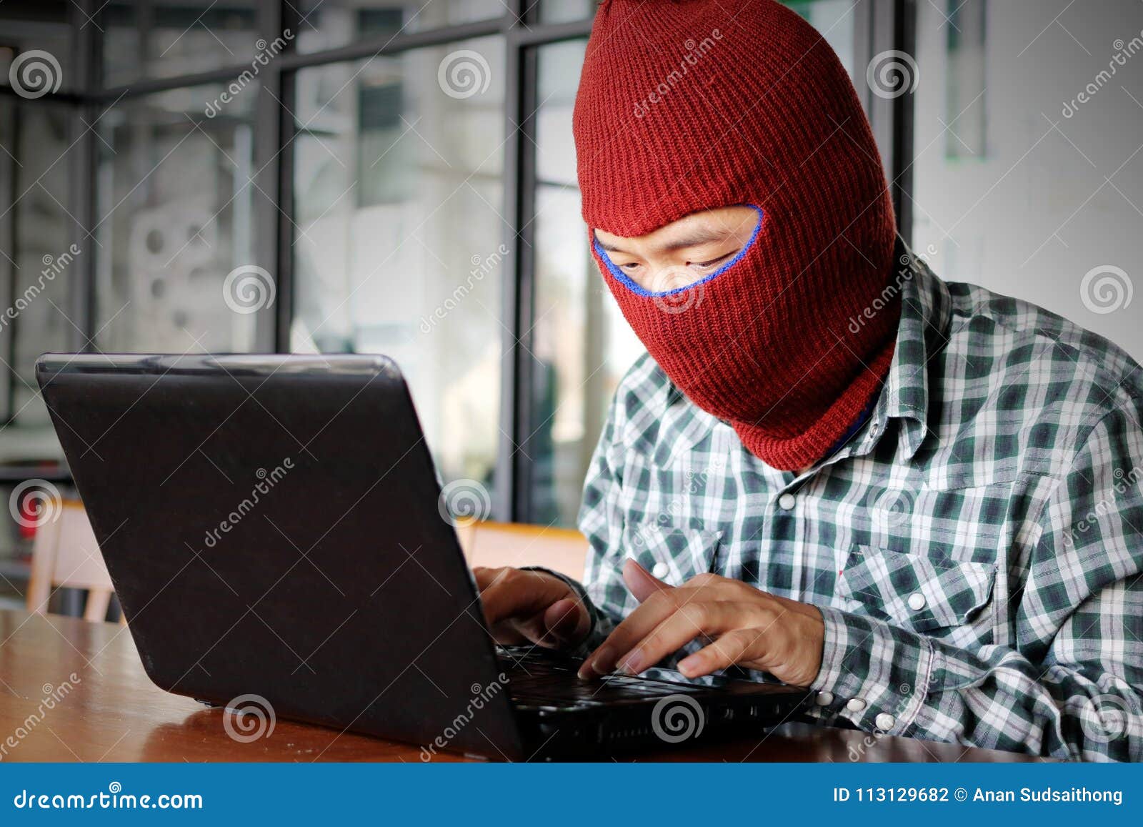 Masked Hacker Wearing a Balaclava Stealing Information Data with Laptop ...