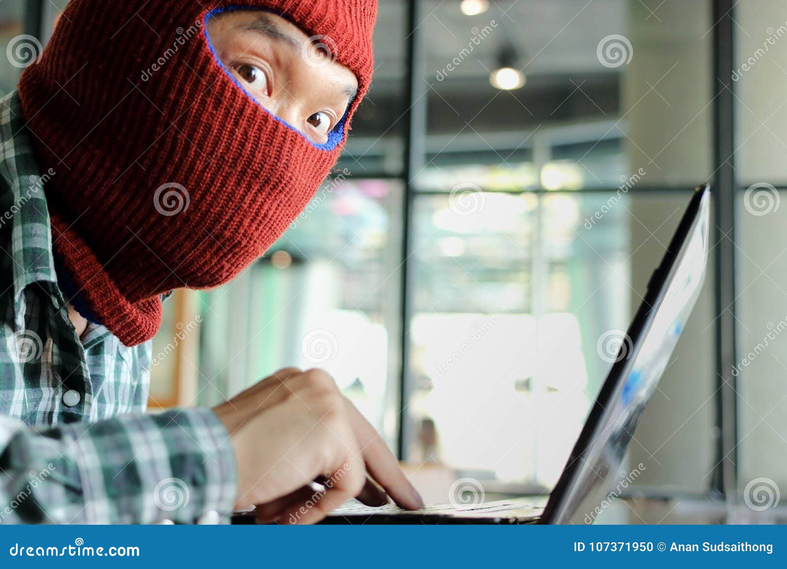 Masked Hacker Wearing a Balaclava Using Laptop Stealing Important ...