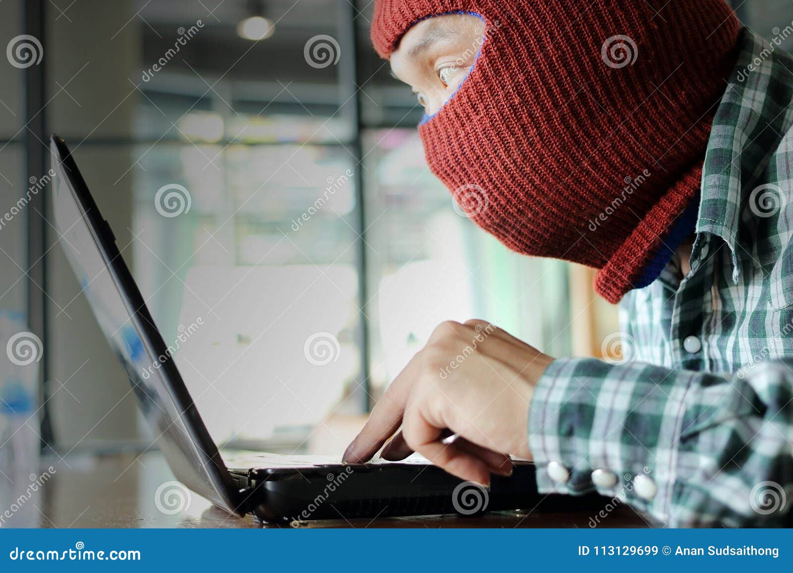 Masked Hacker Wearing a Balaclava Using Laptop Stealing Important ...