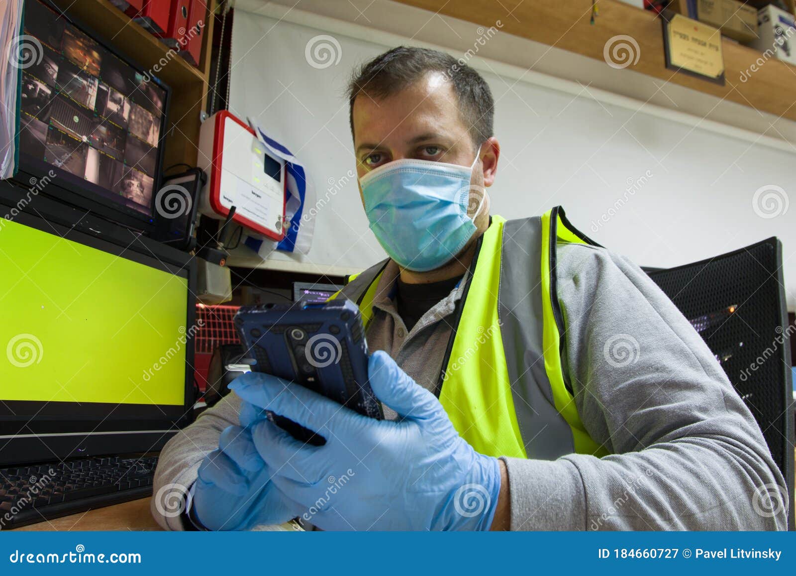 A Masked Man at a Table Works on a Computer in Office Stock Image ...