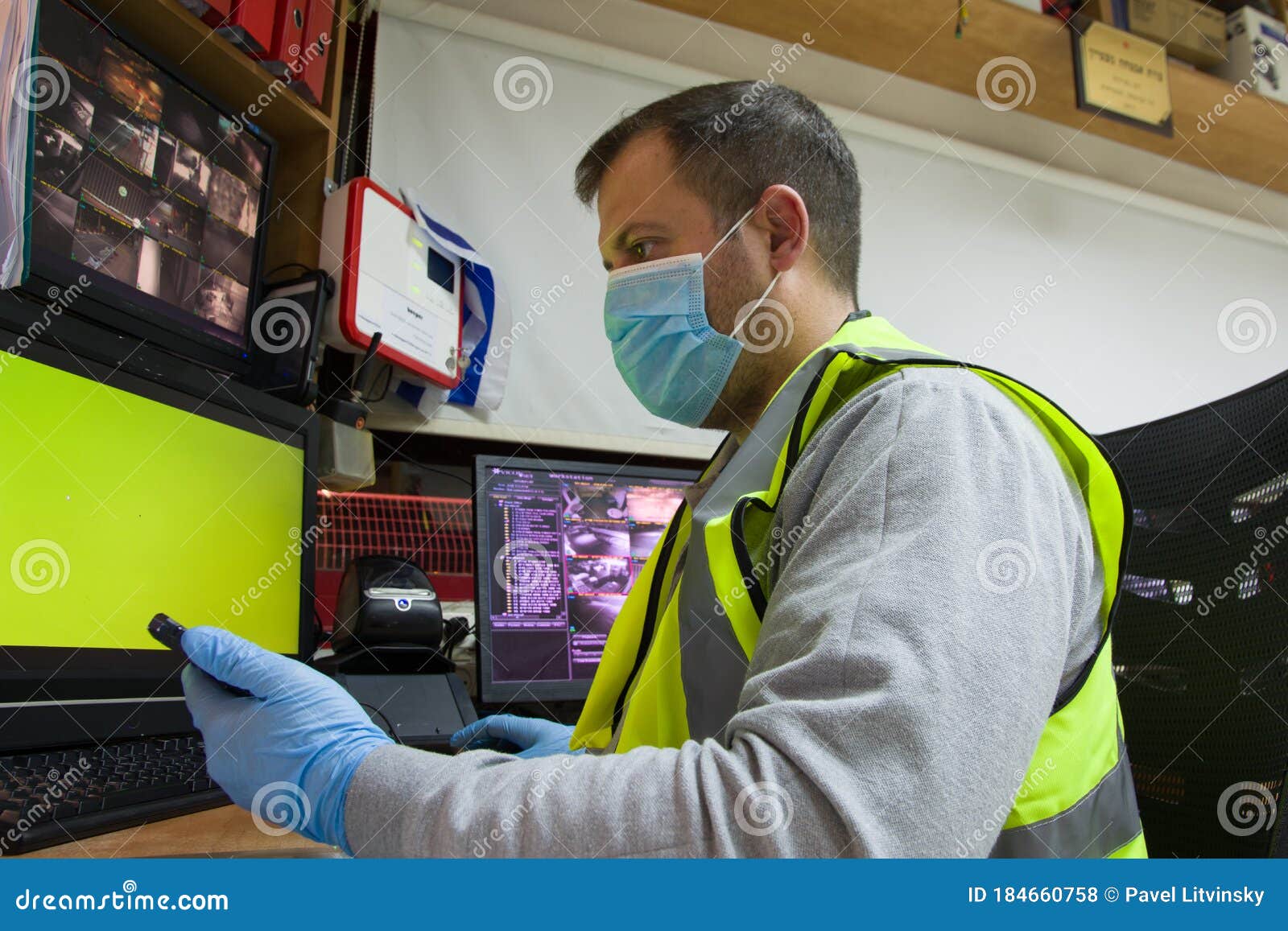 A Masked Man at a Table Works on a Computer in Office Stock Photo ...