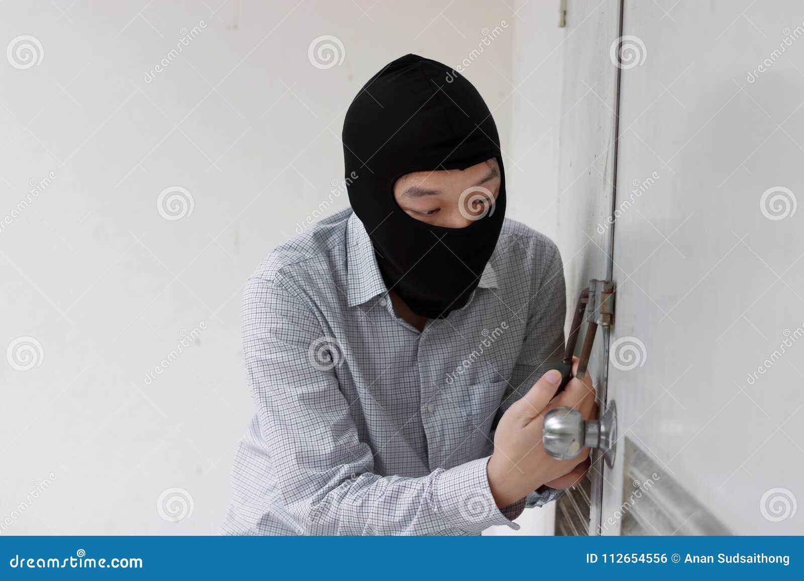 Masked Robber Using a Lock Picking Tool To Breaking and Entering into a ...
