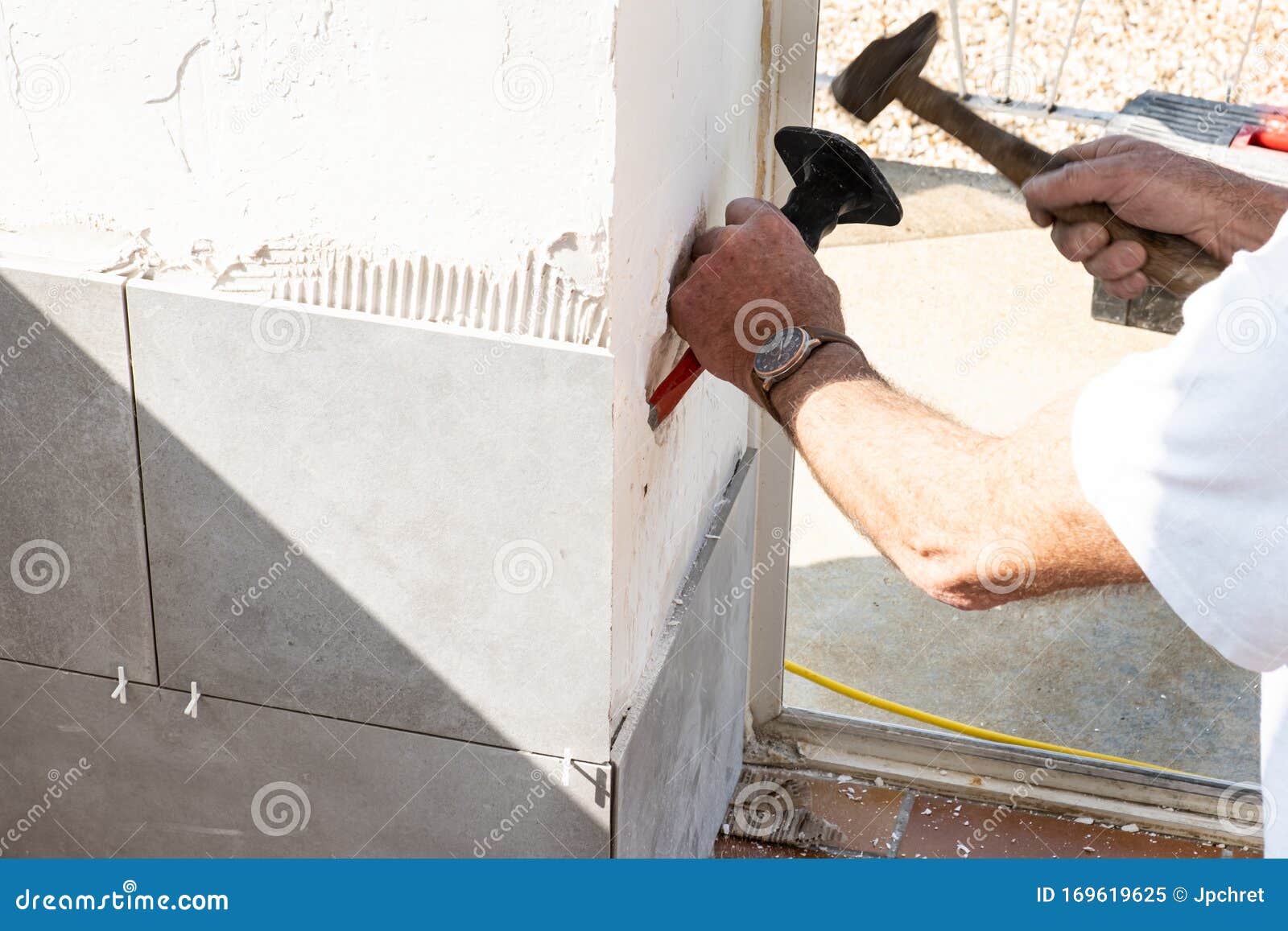 The Mason Prepares the Wall with a Chisel before Laying a Ceramic Tile ...