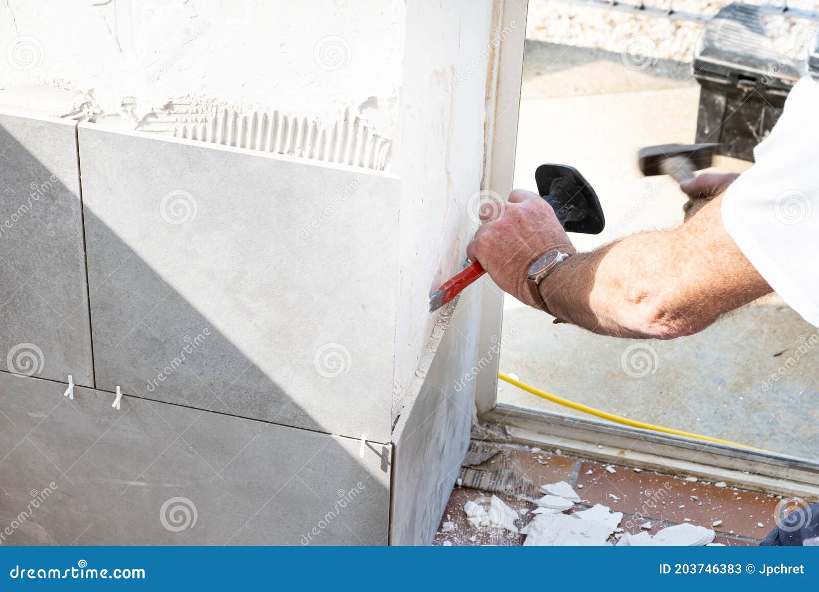 The Mason Prepares the Wall with a Chisel before Laying a Ceramic Tile ...