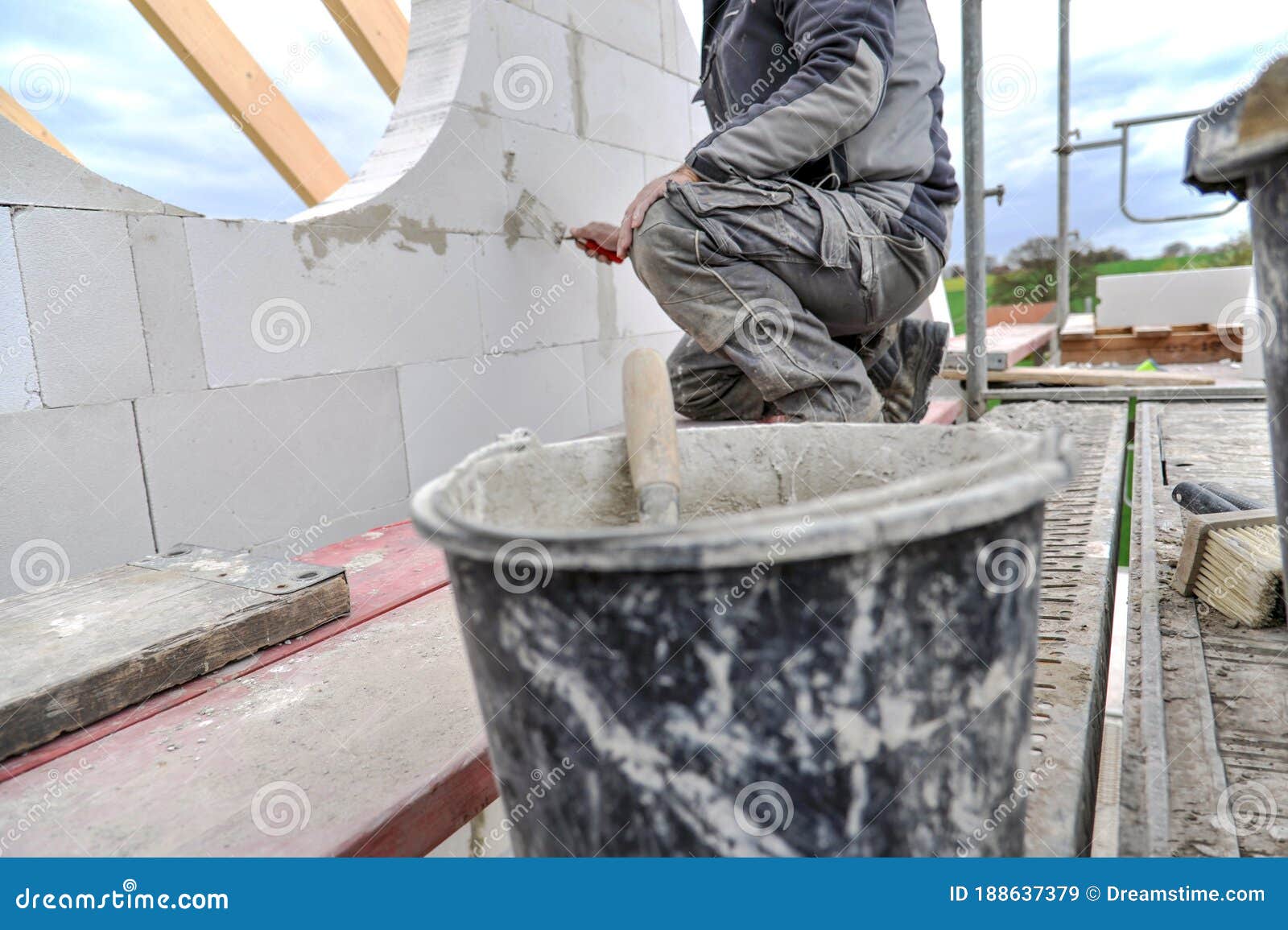 Mason is Working on a Scaffold at a Construction Site on a New Building ...