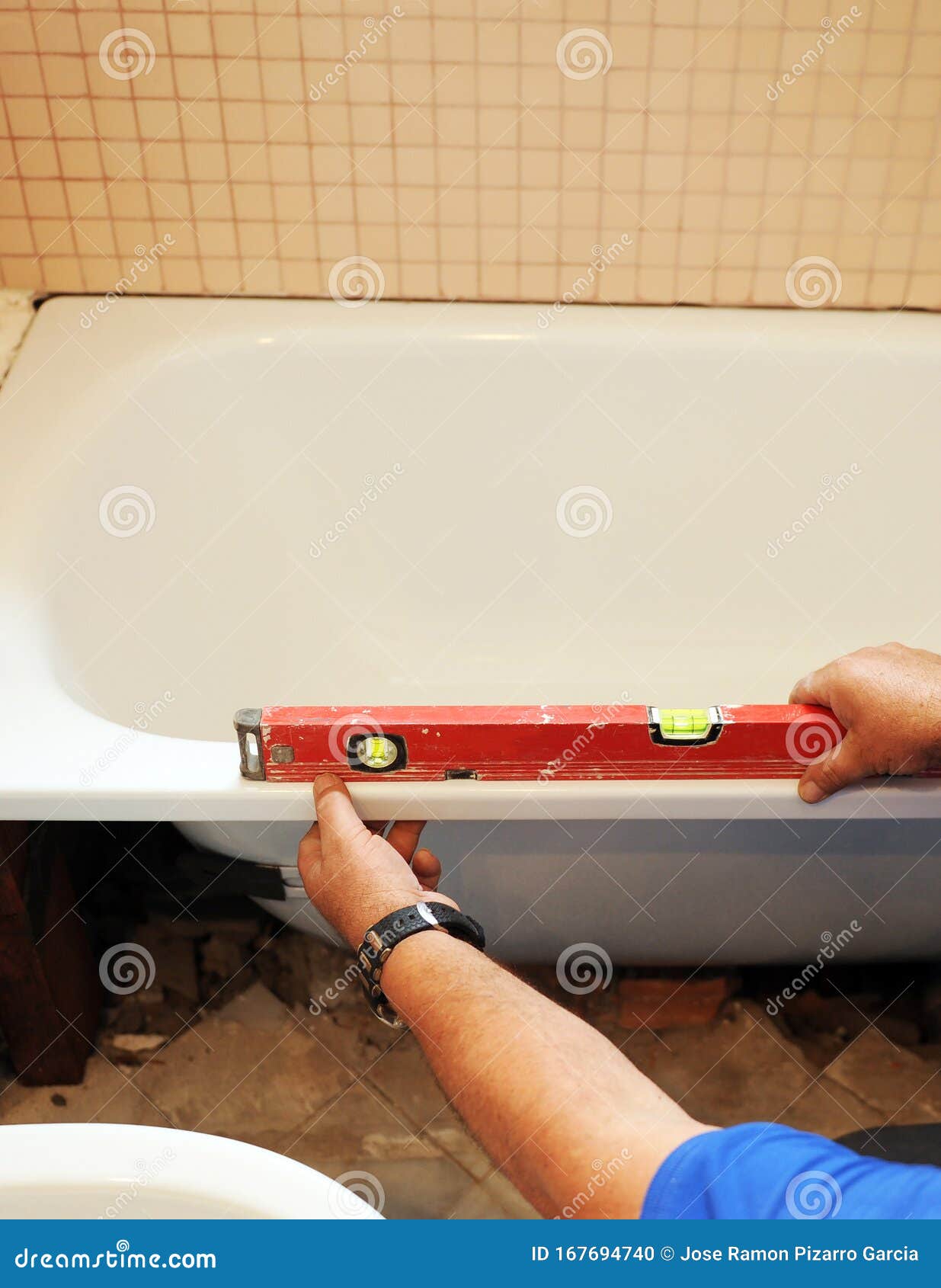 Bricklayer Checking with a Level Tool the Installation of a New Bathtub ...
